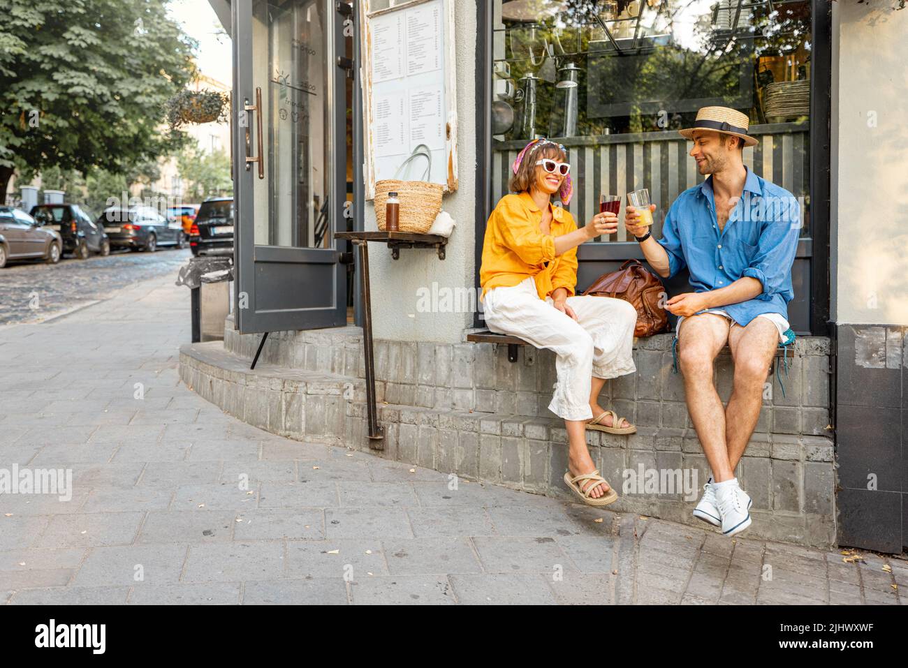 Stylish couple of friends hang out at cafe on a street Stock Photo - Alamy