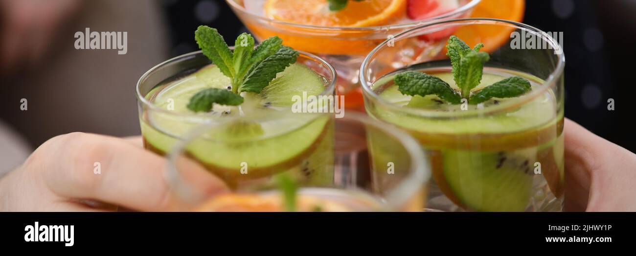 Group of people with cooling drinks make clink with glasses, raise ...
