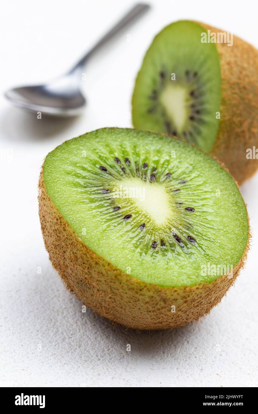 Two kiwi halves and spoon. Close up. Top view. White background Stock ...