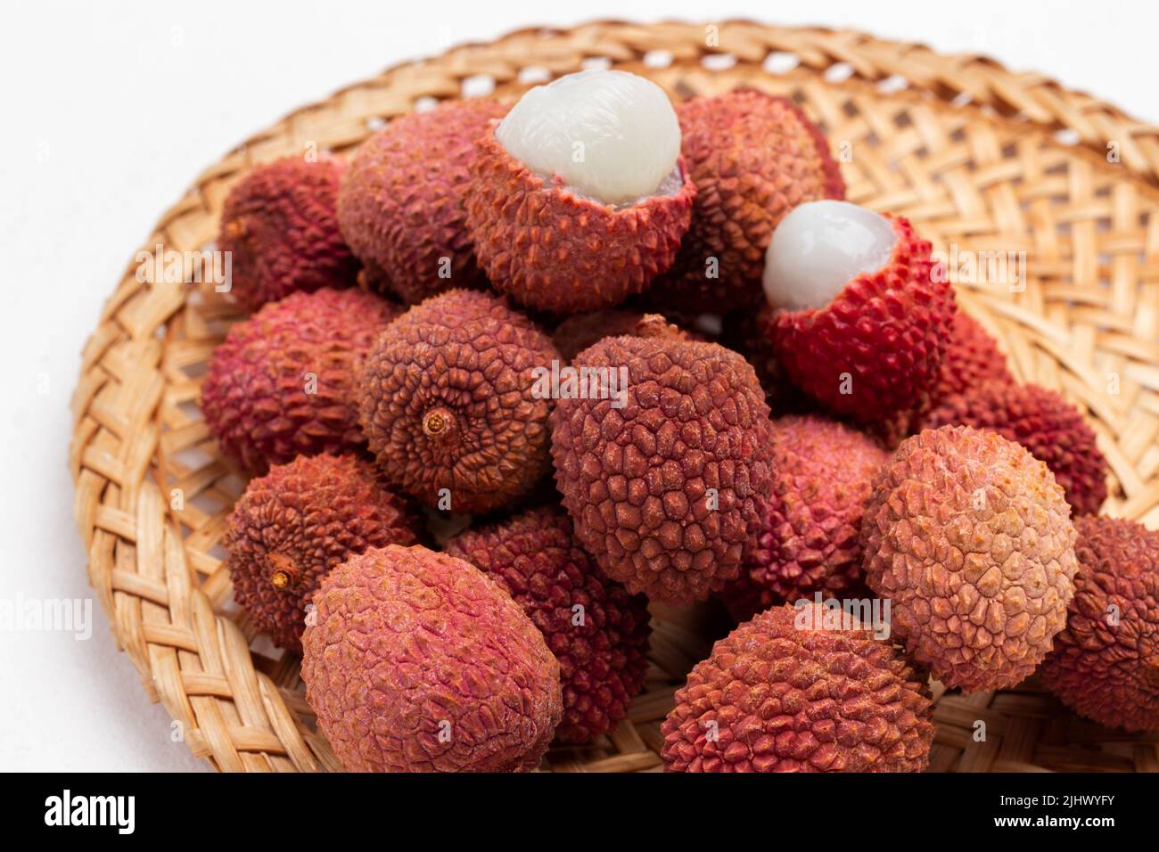 Lychee fruit on wicker plate. Close up. Top view. White background ...
