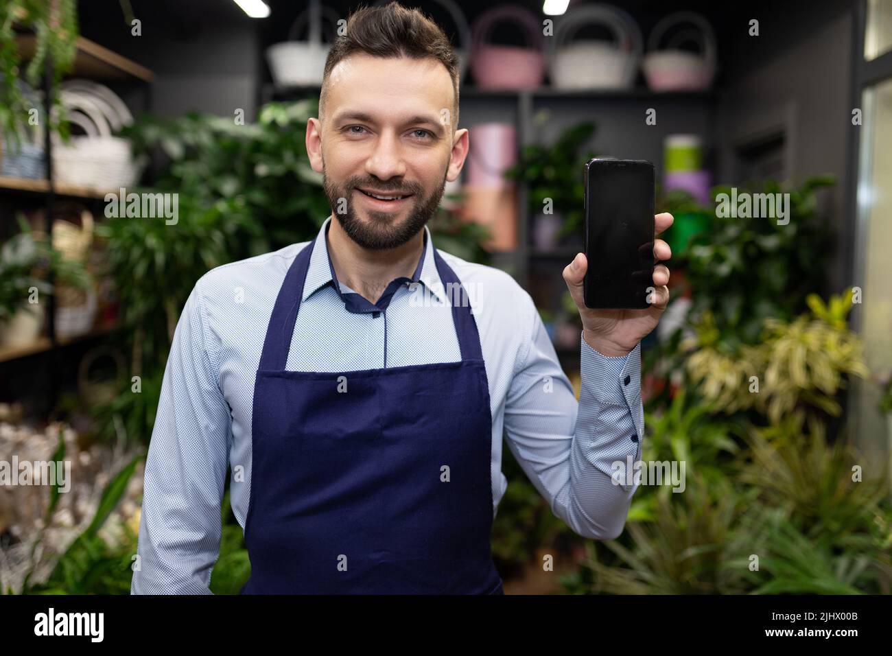 flower shop manager showing smartphone screen Stock Photo - Alamy