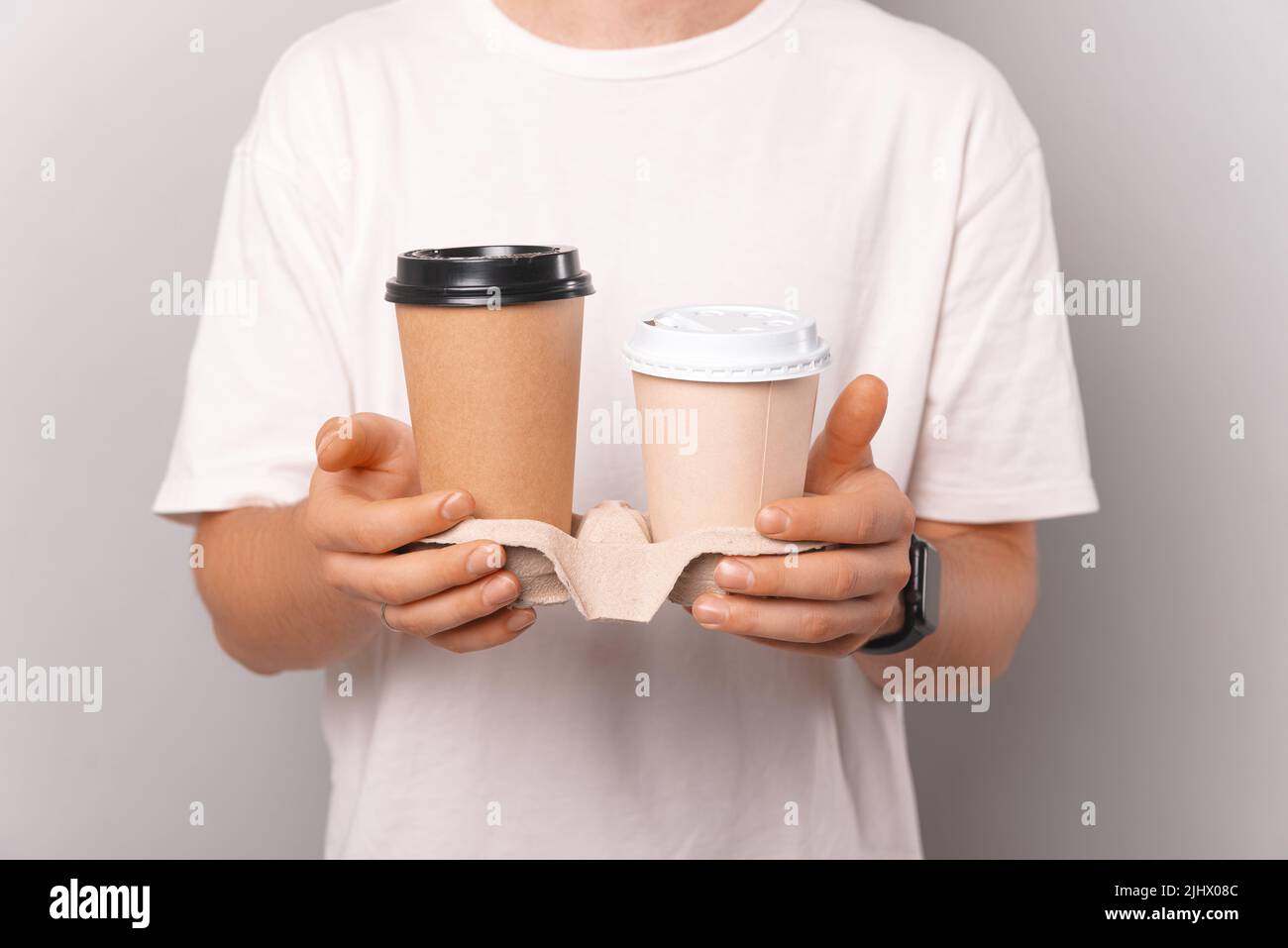 Closeup photo of a mans hands holding two cups of paper in a cup ...