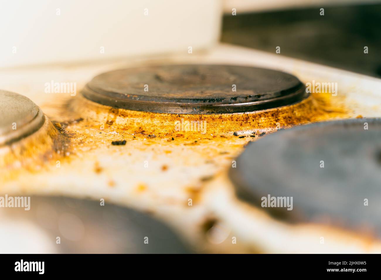 Old kitchen electric stove in heavy brown pollution and soot close up ...