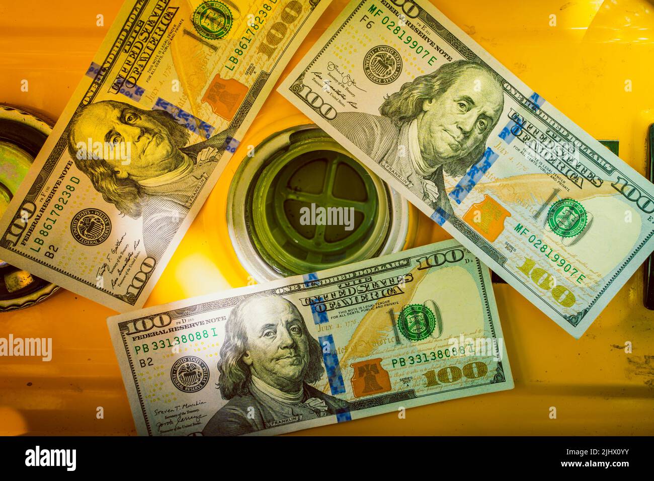 Hundred dollar banknotes near the filler neck of the tank close-up, top ...