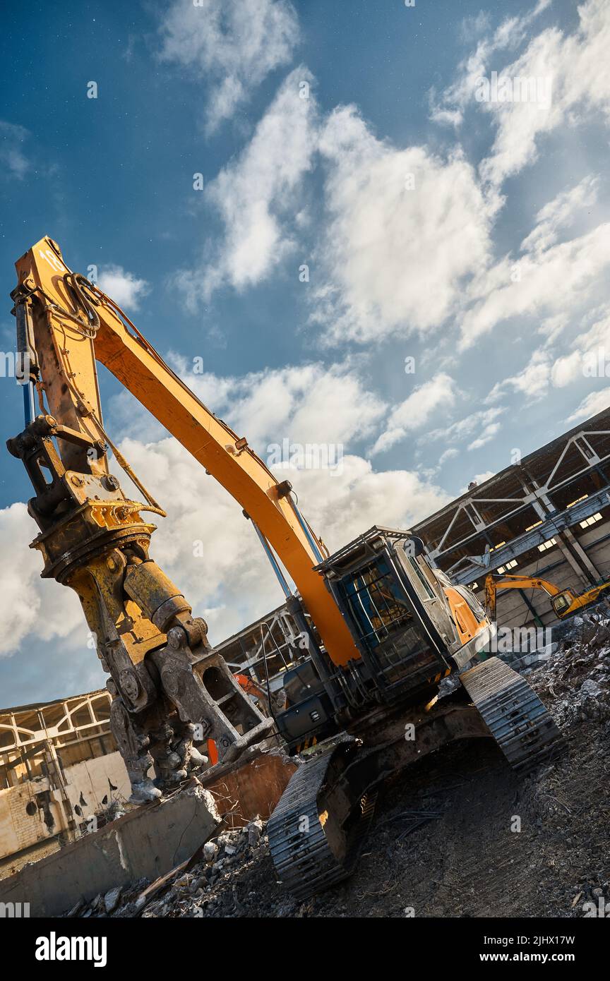 Excavator destroyer equipped with hydraulic scissors Stock Photo - Alamy