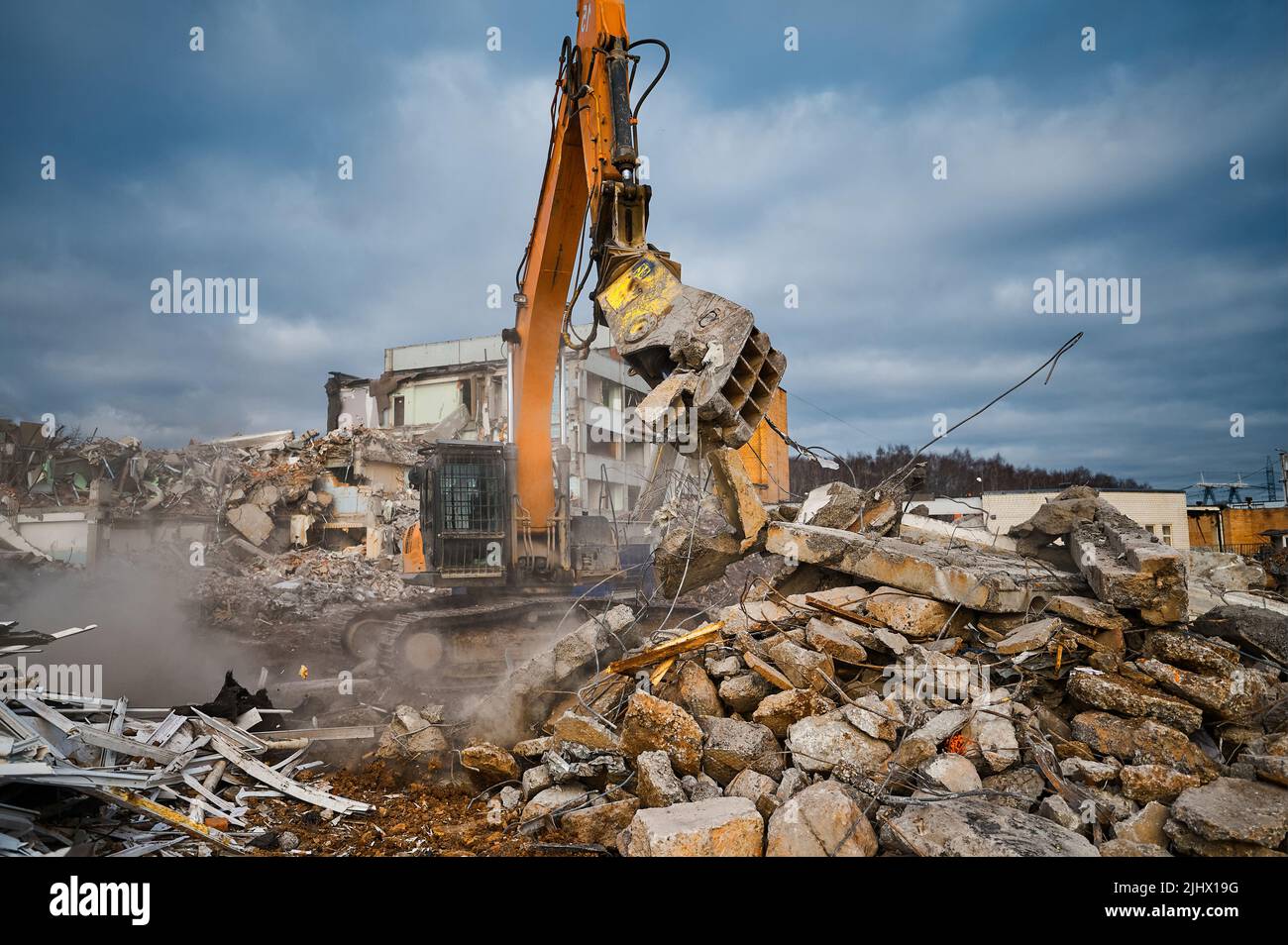 Excavator with hydraulic press breaks concrete leftovers Stock Photo - Alamy