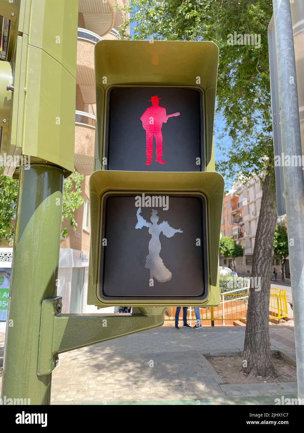 A vertical shot of a traffic light showing red with a dancer and ...