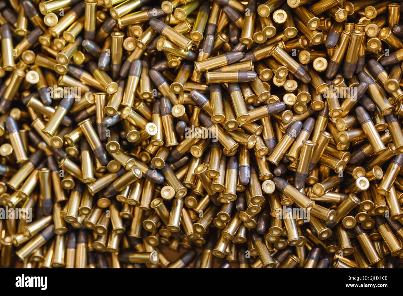 Heap of black and golden small-caliber bullets on table Stock Photo - Alamy