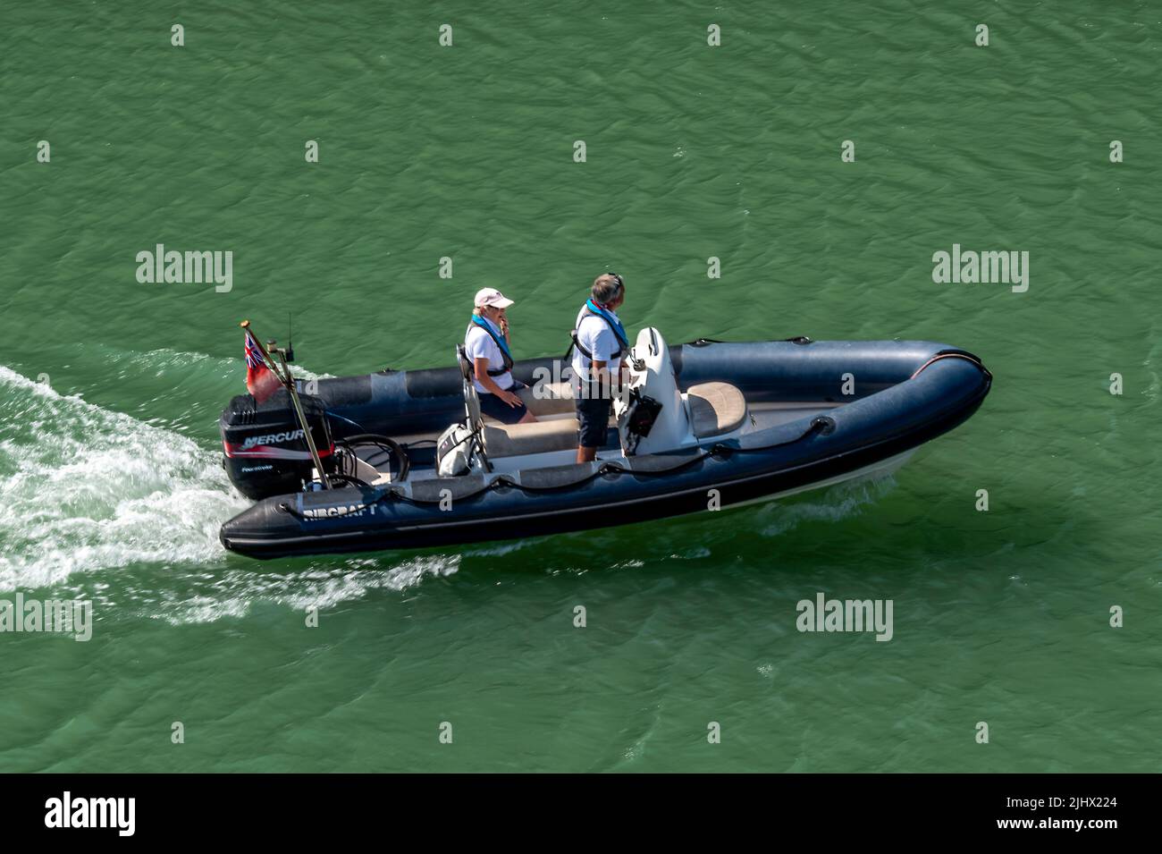 two men in a small rigid inflatable boat or rib with large outboard ...