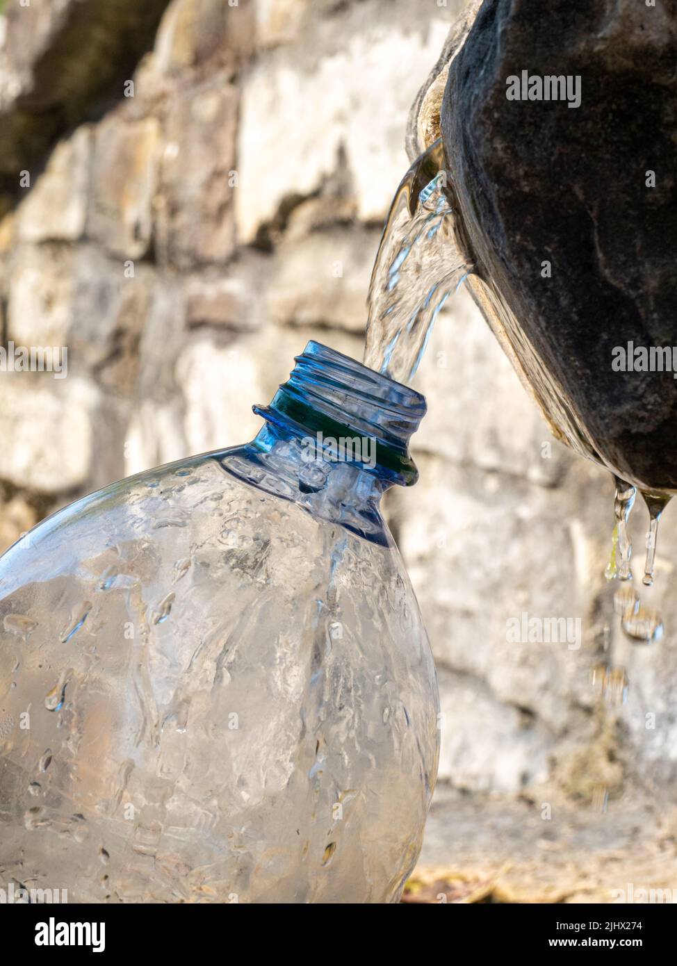 Drink spring water pouring in to bottle over sunlight and natural ...