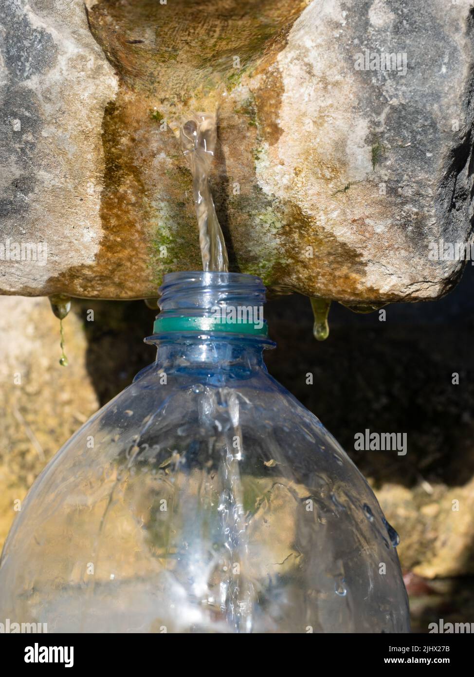 Drink spring water pouring in to bottle over sunlight and natural ...