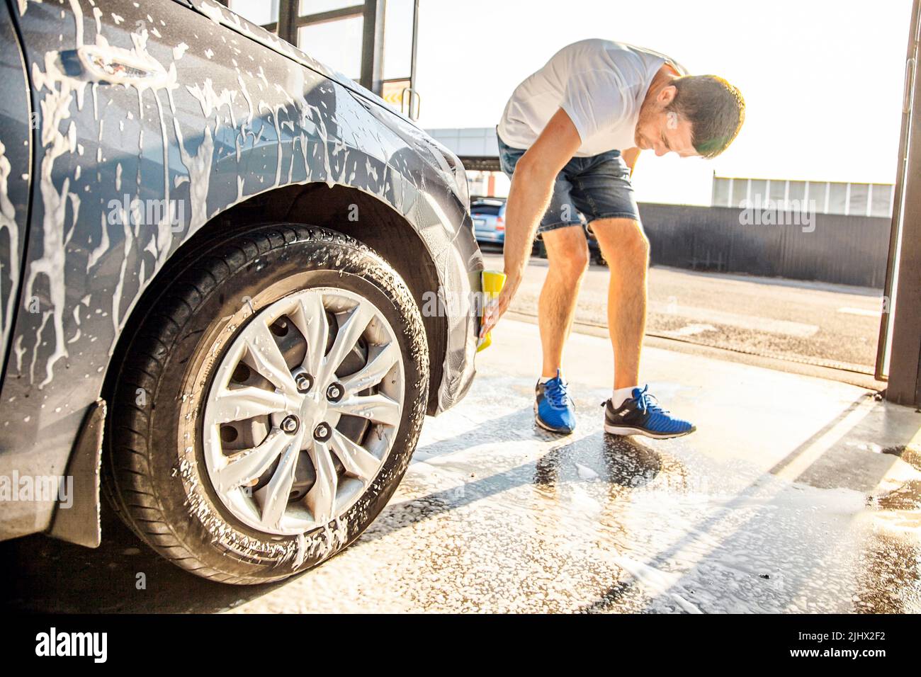 A man washes his car with foam at a self-service car wash Stock Photo ...