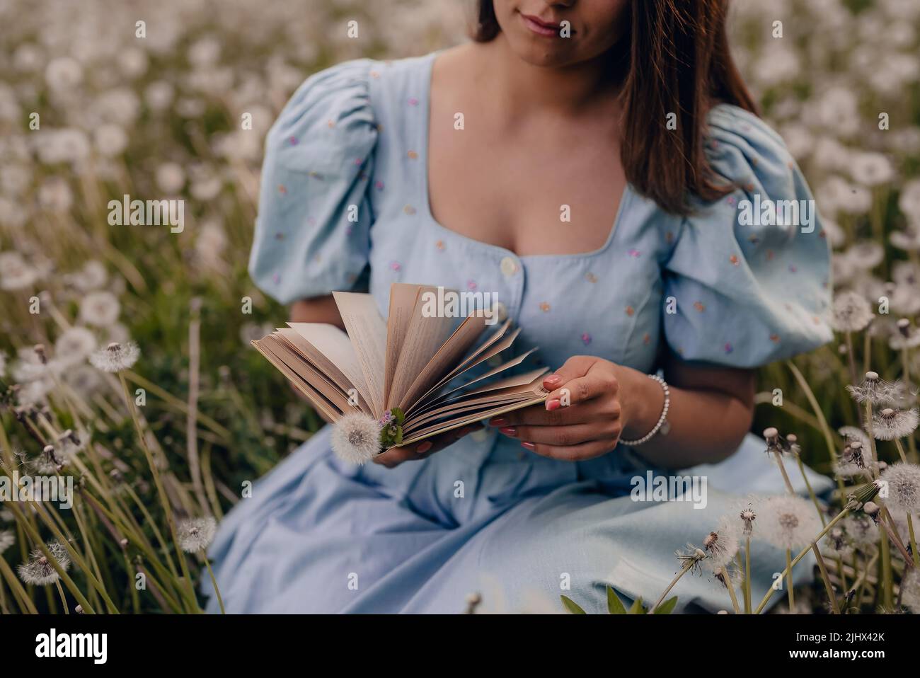 Woman flips through pages of paper book. Lady in retro or vintage dress ...