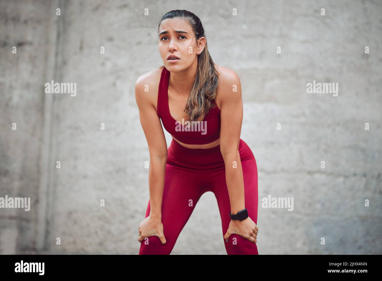 What a run. an attractive young female athlete looking tired while ...