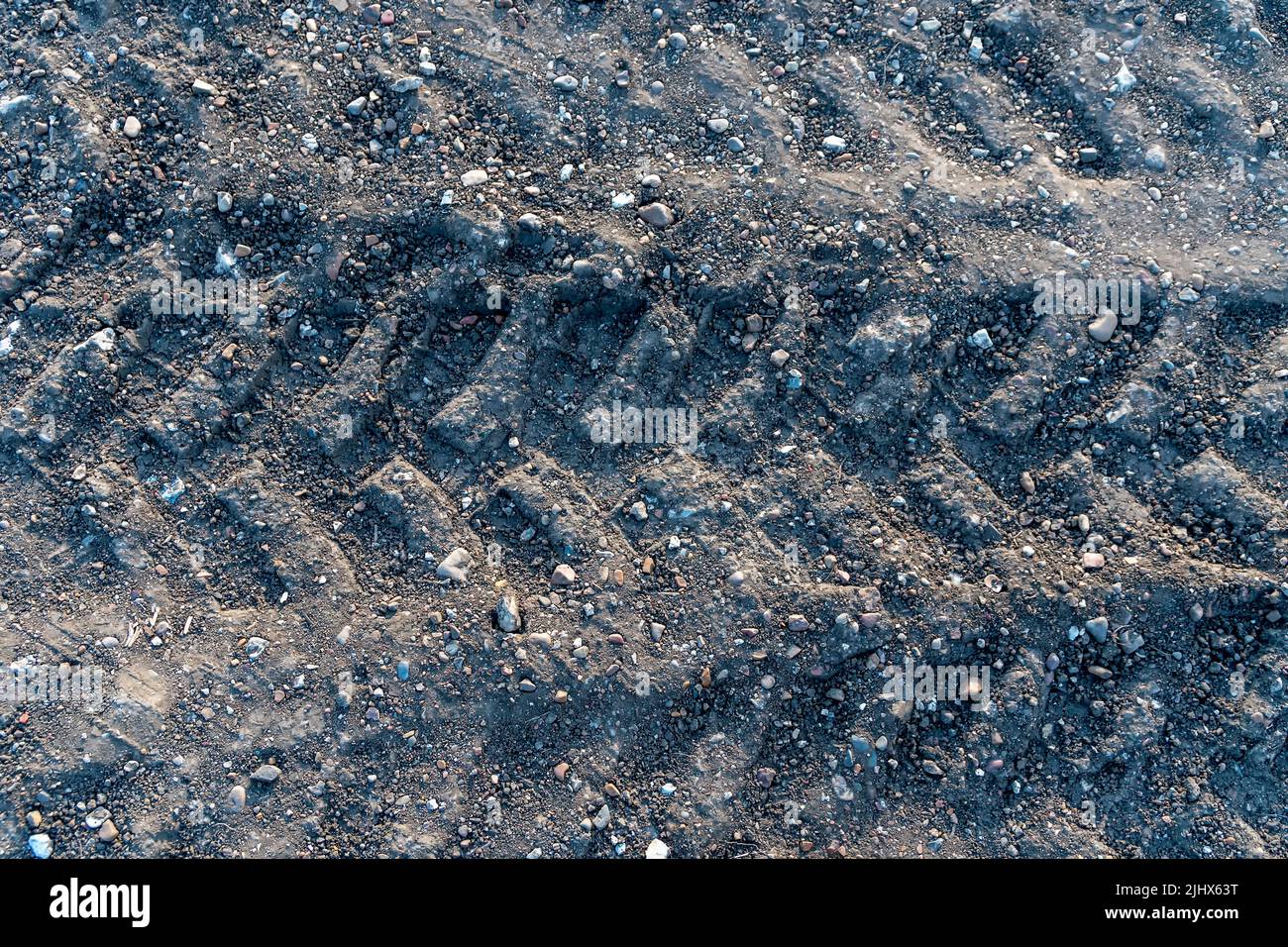 Textured surface of earthen road, on which trace of tread of automobile ...