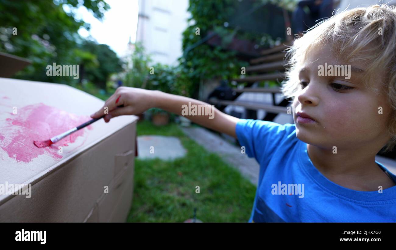 Artistic child painting outside in home garden. Artistic child playing ...