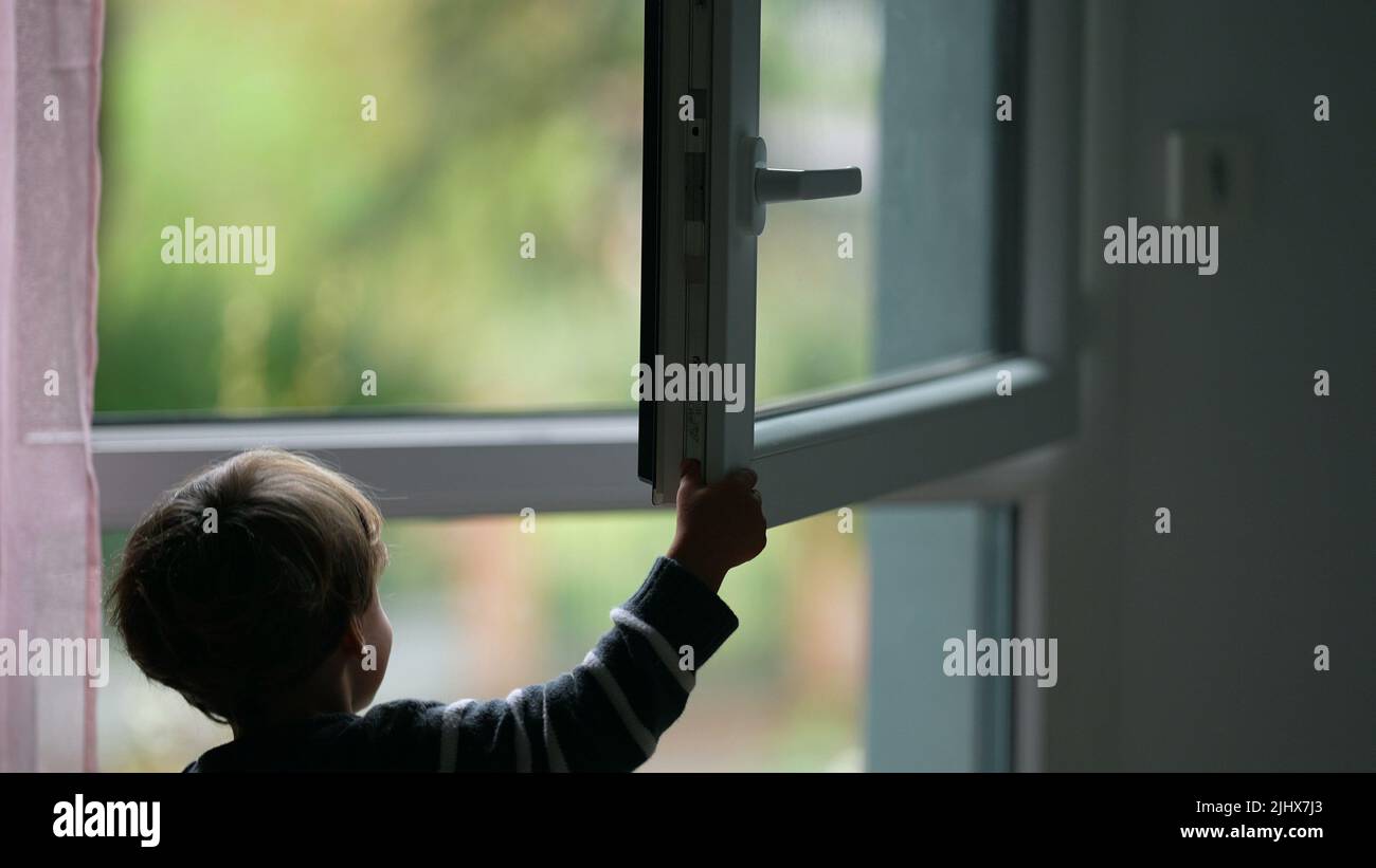 Little boy closing window. Child closes open window Stock Photo - Alamy