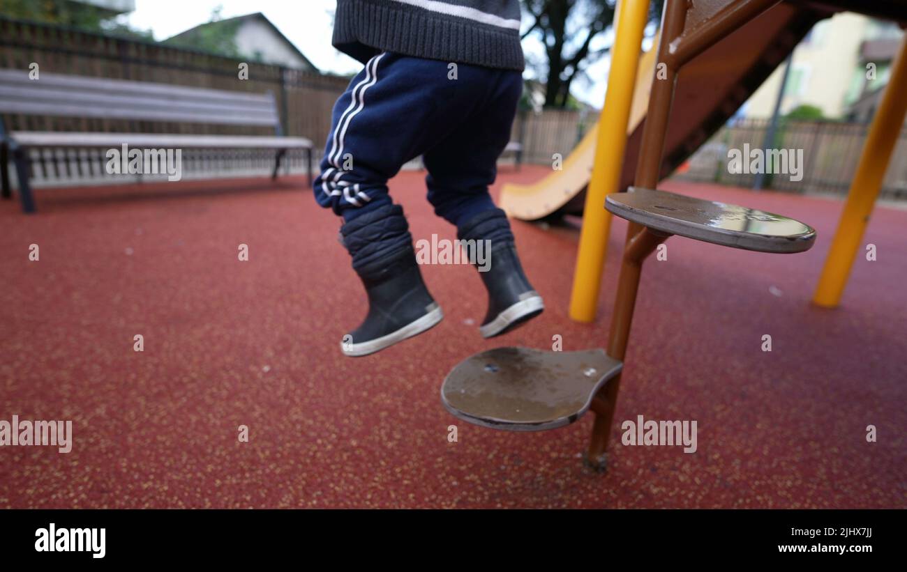 Little boy stepping down from playground structure steps equipment ...