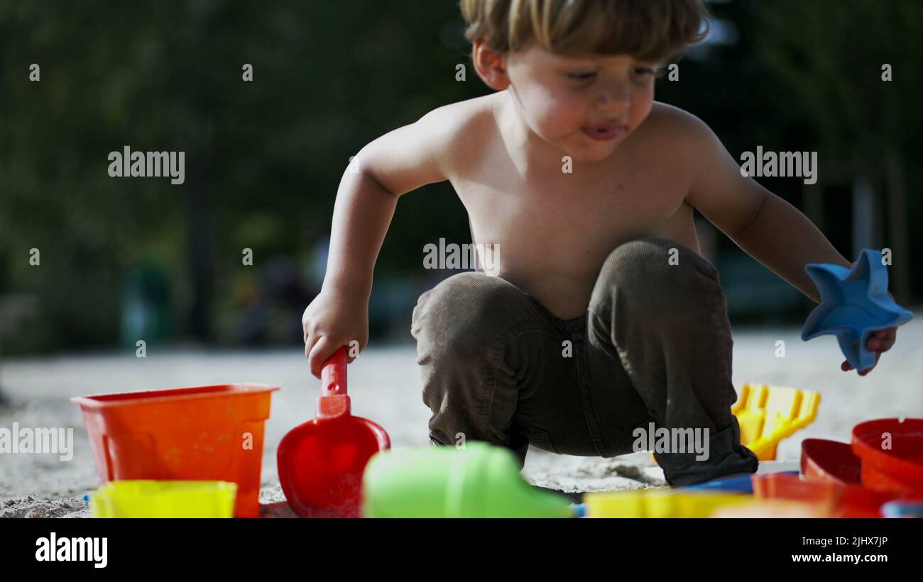 Little boy playing with shovel and bucket outside in sandbox Stock ...