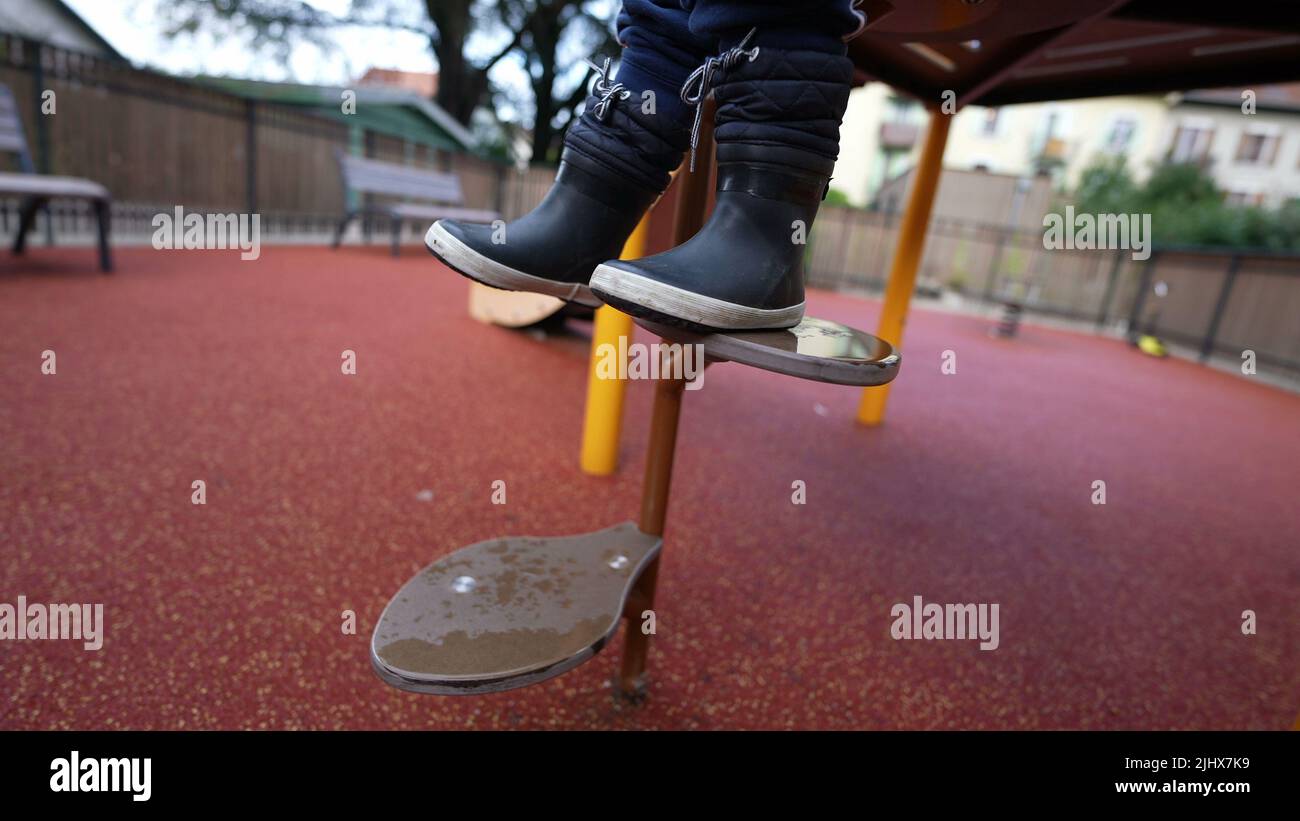 Little boy stepping down from playground structure steps equipment ...