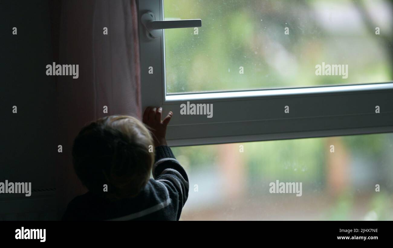 Child closing window. Toddler closes window Stock Photo - Alamy