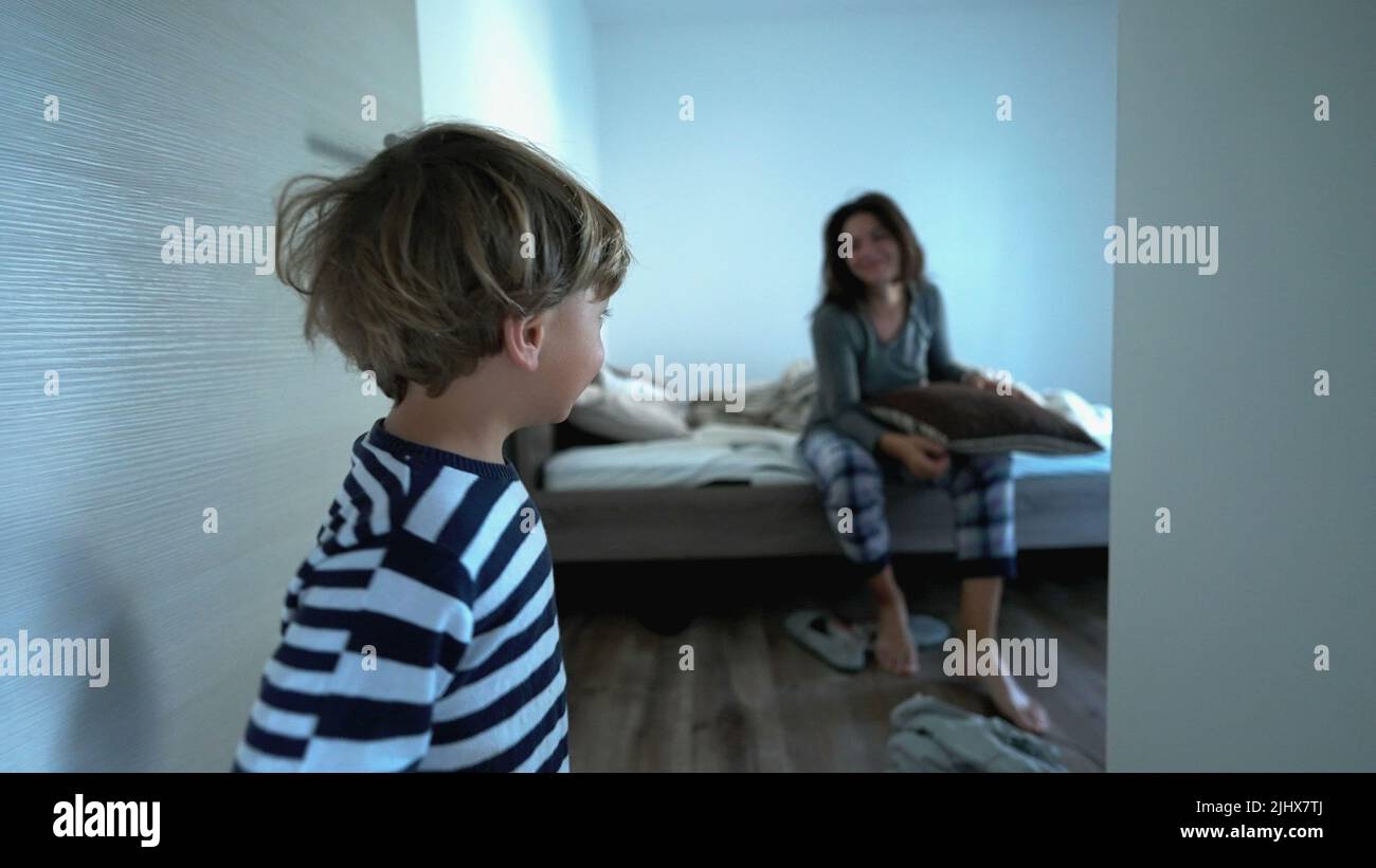Playful mother and child playing with pillow fight in morning bed ...