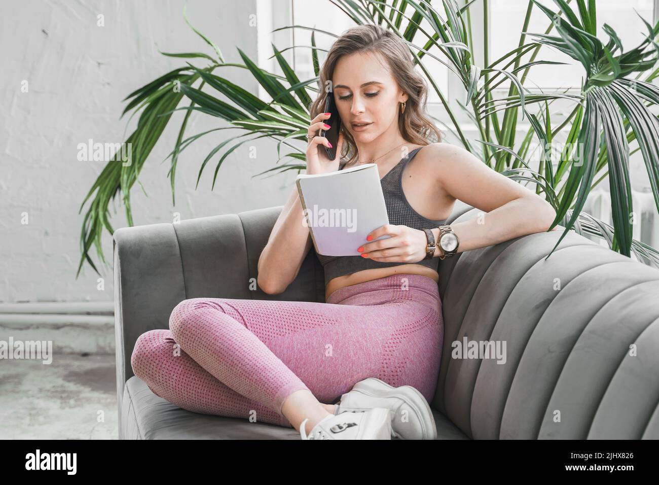 Sporty slim woman yoga coach laying on sofa couch in sportswear with ...