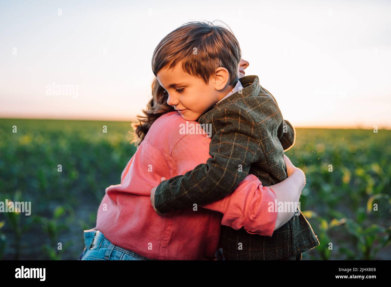 Loving smiling son hugs mom tightly. Tender family scene. Cute 3 year ...