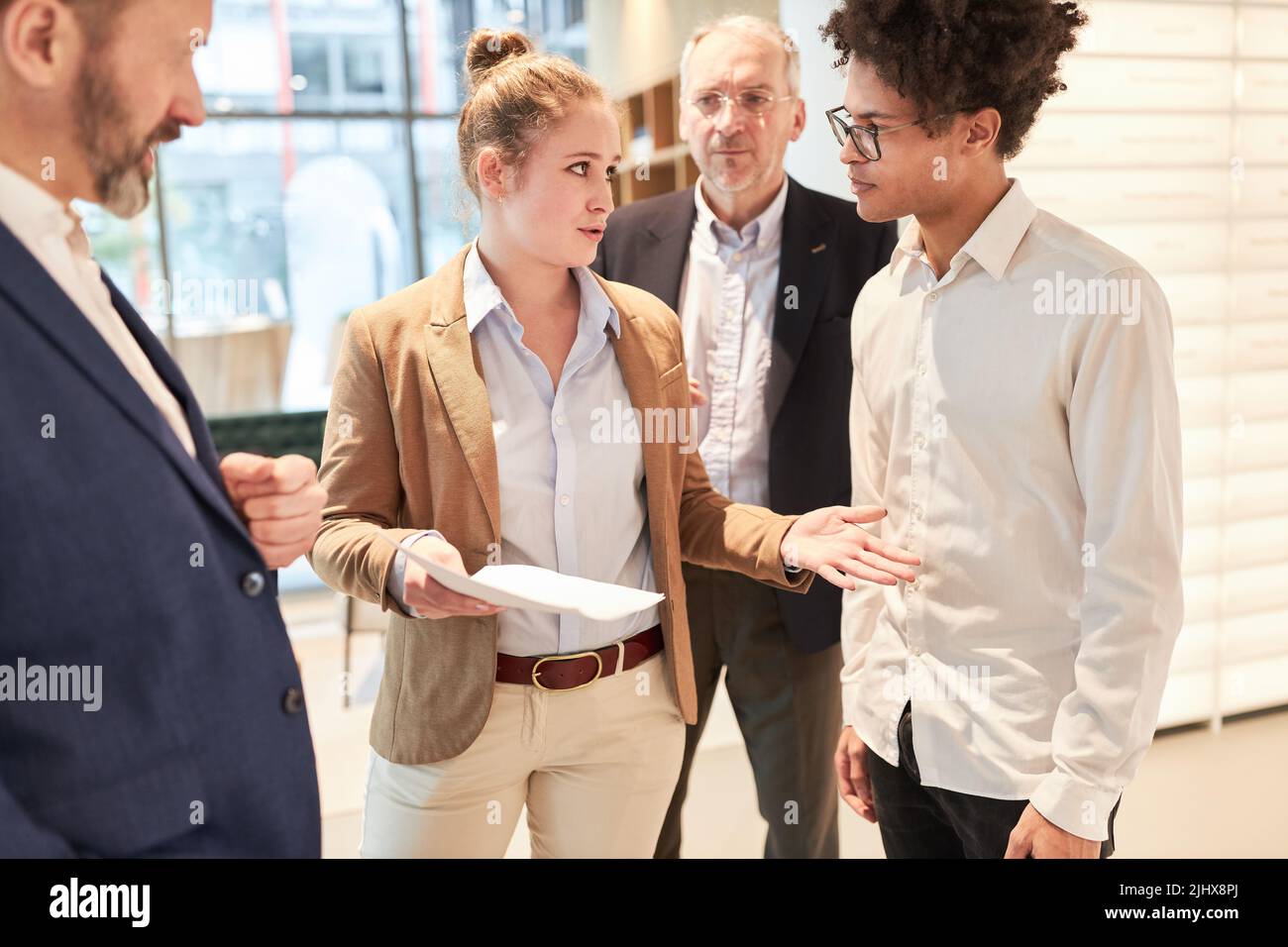 Young woman as a start-up founder discusses with colleagues in a ...
