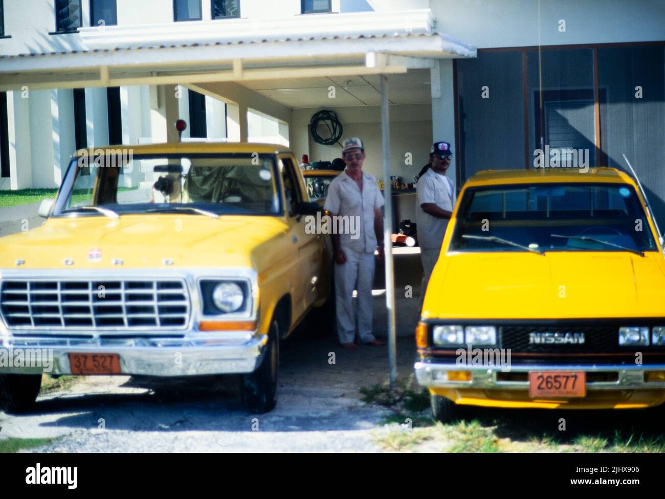 Utility workers stand by their vehicles at Stake Bay, Cayman Brac ...