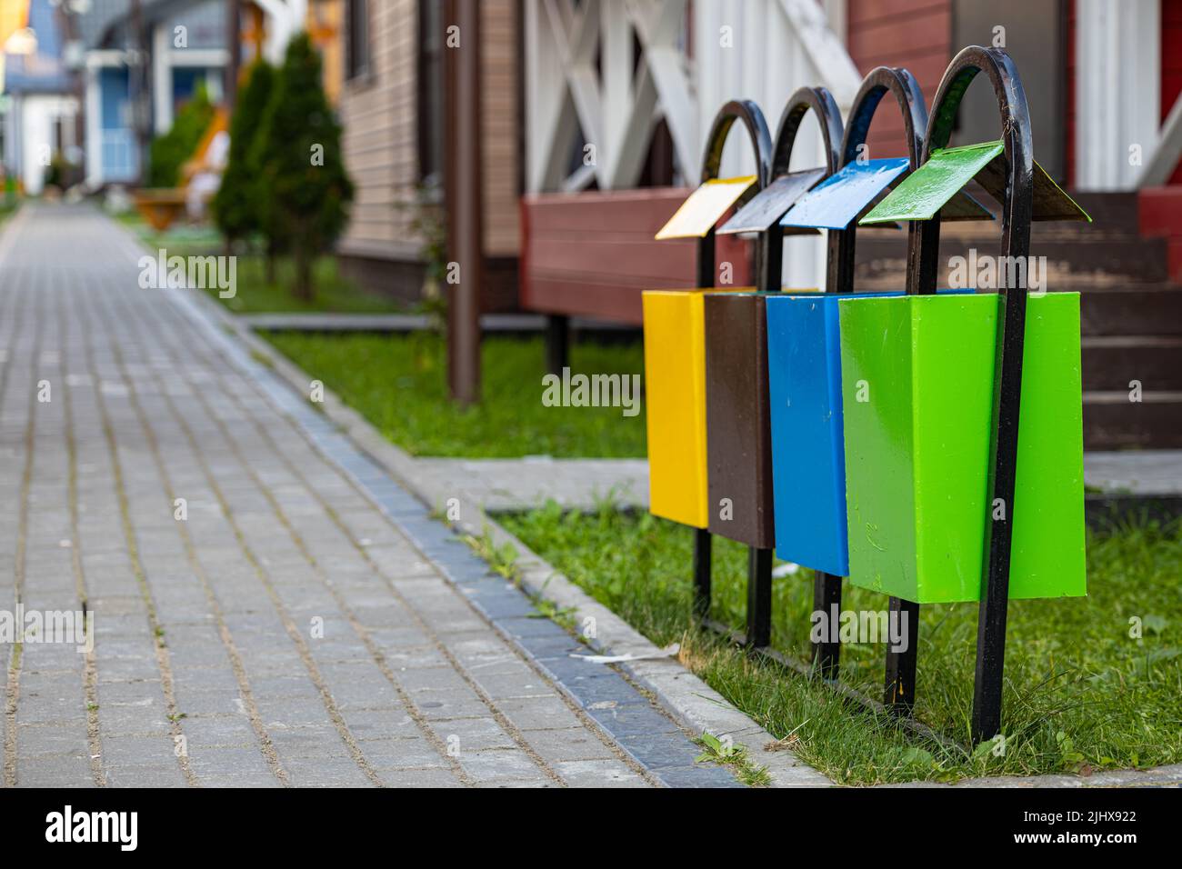multi-colored garbage containers line the path. High quality photo ...
