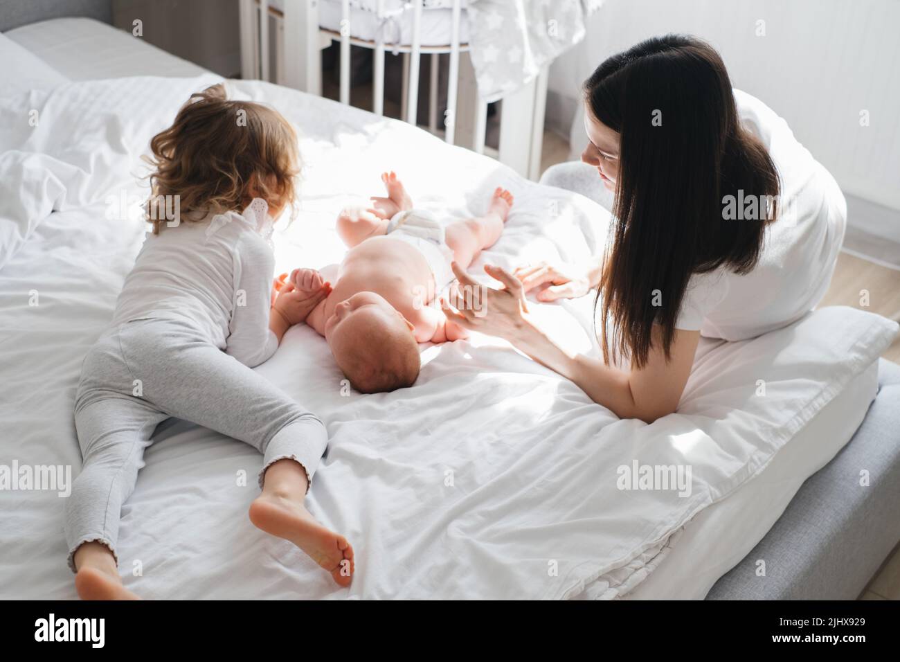 Older sister, mother and baby brother communicating. Two cute little ...