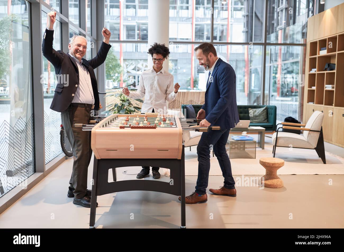 Business man wins playing table football at the foosball table in the ...