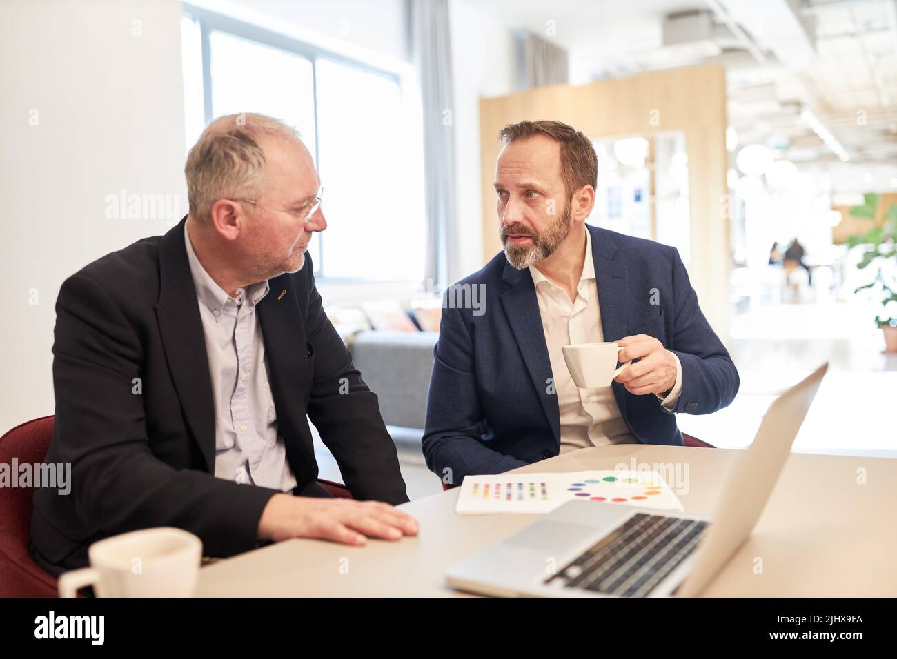 Two business people as colleagues having a casual conversation at the ...