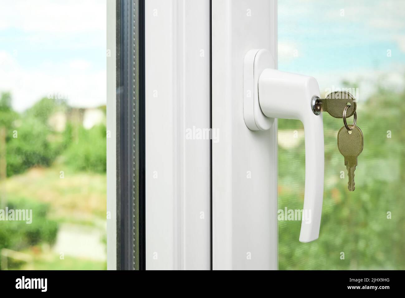 Plastic window locked with keys in the keyhole Stock Photo - Alamy