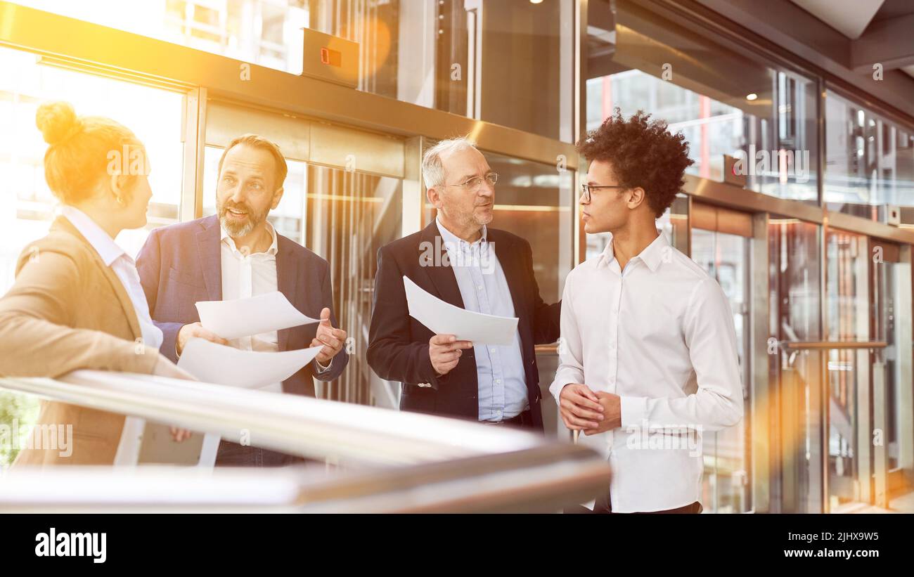 Group of business people consulting and collaborating in bright office ...