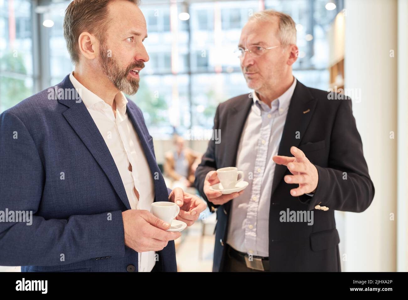 Two businessmen as business partners in a coffee break making small ...