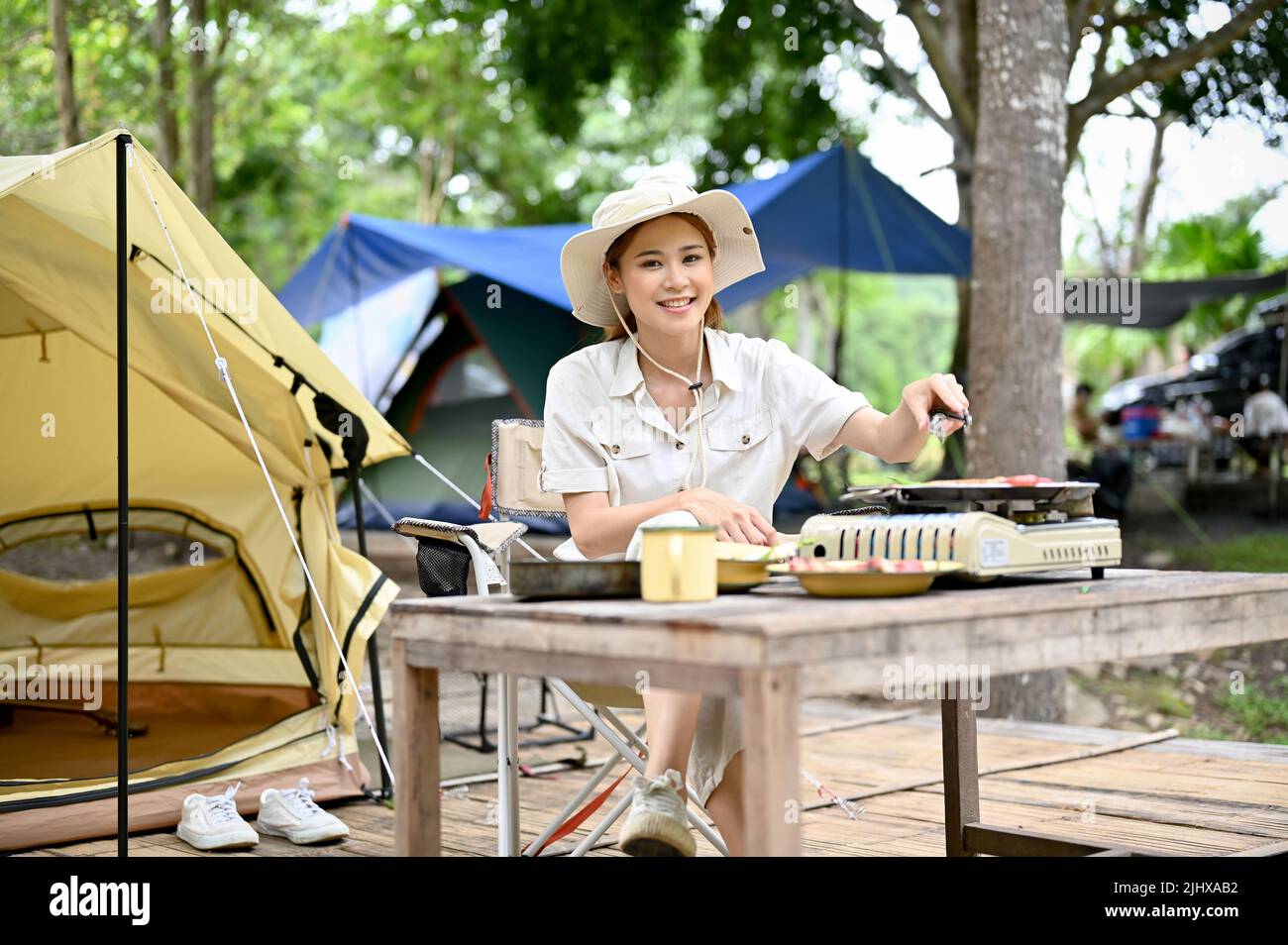 Beautiful millennial asian female enjoy camping at the campsite ...
