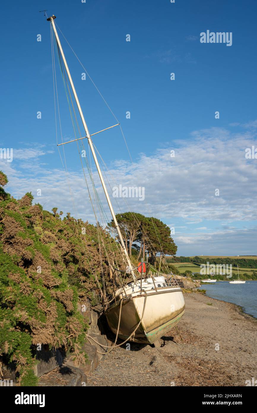 abandoned scrap value sail yacht beached on an estuary bank Stock Photo ...