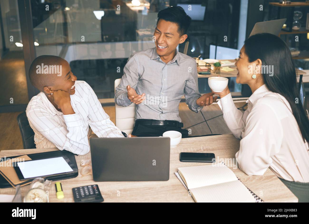 A much needed break. a group of businesspeople working late in a modern ...