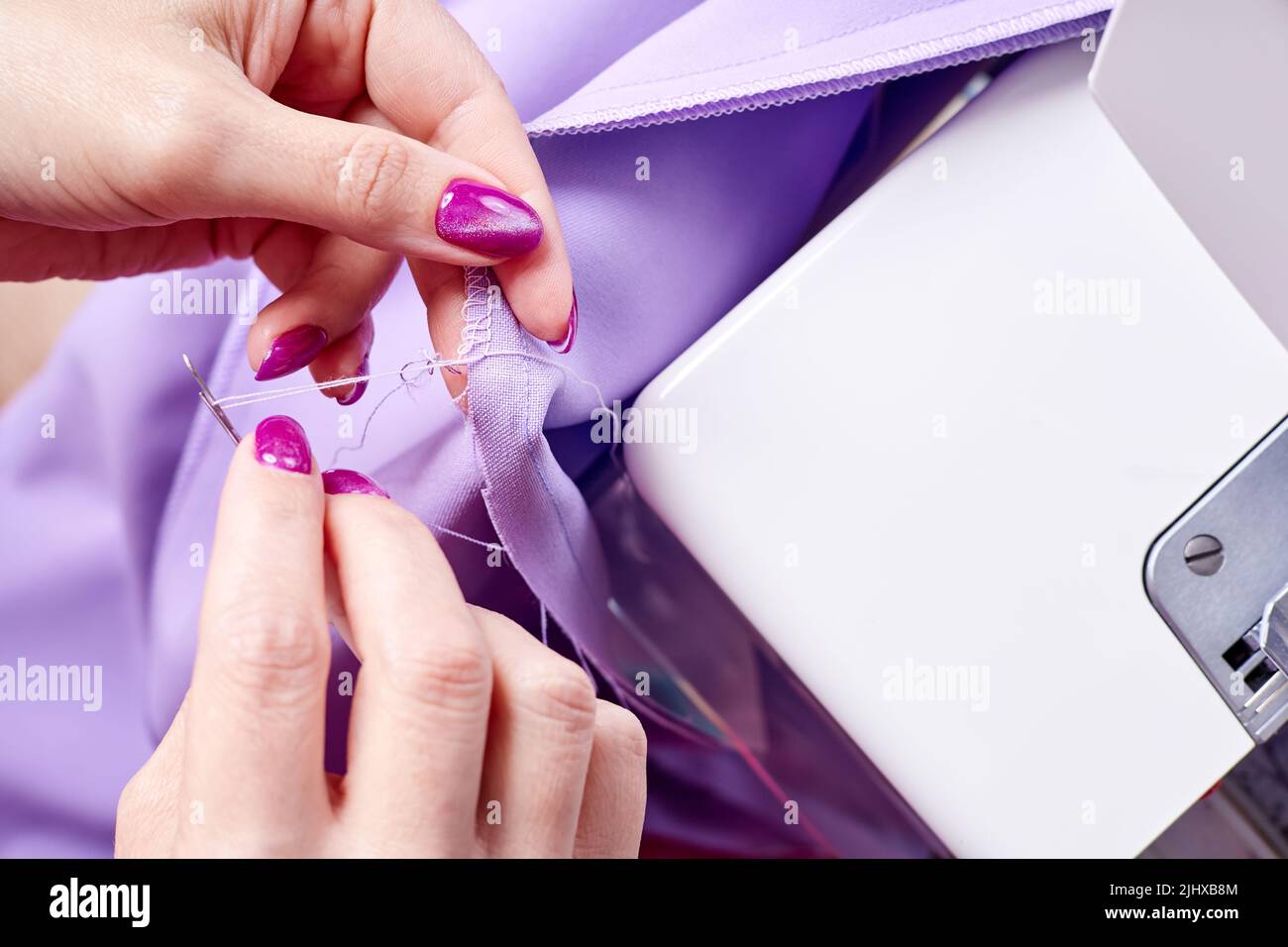 Close-up of the girl rips the seam on the dress using a seam ripper ...