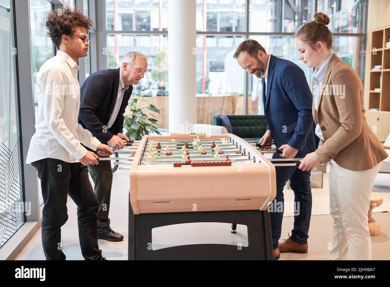 Group of business people at the foosball table playing table football ...