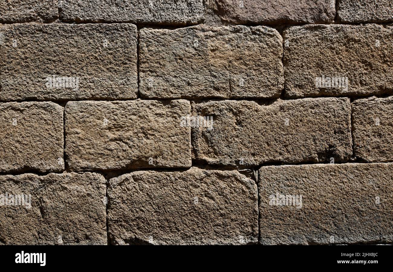 Old wall of rectangular stone bricks that are part of an old bridge ...