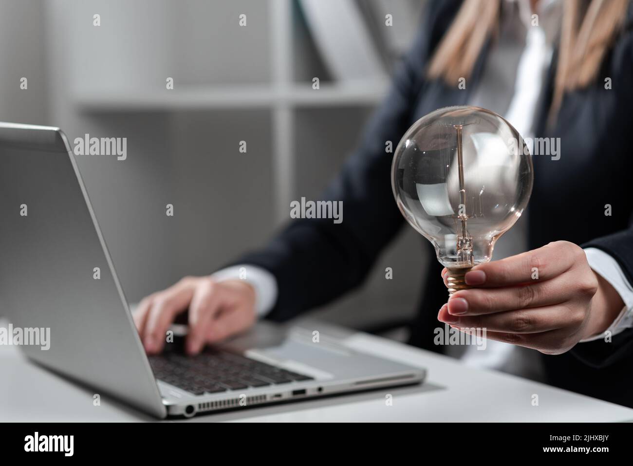Businesswoman Typing Recent Updates On Lap Top On Desk Holding ...