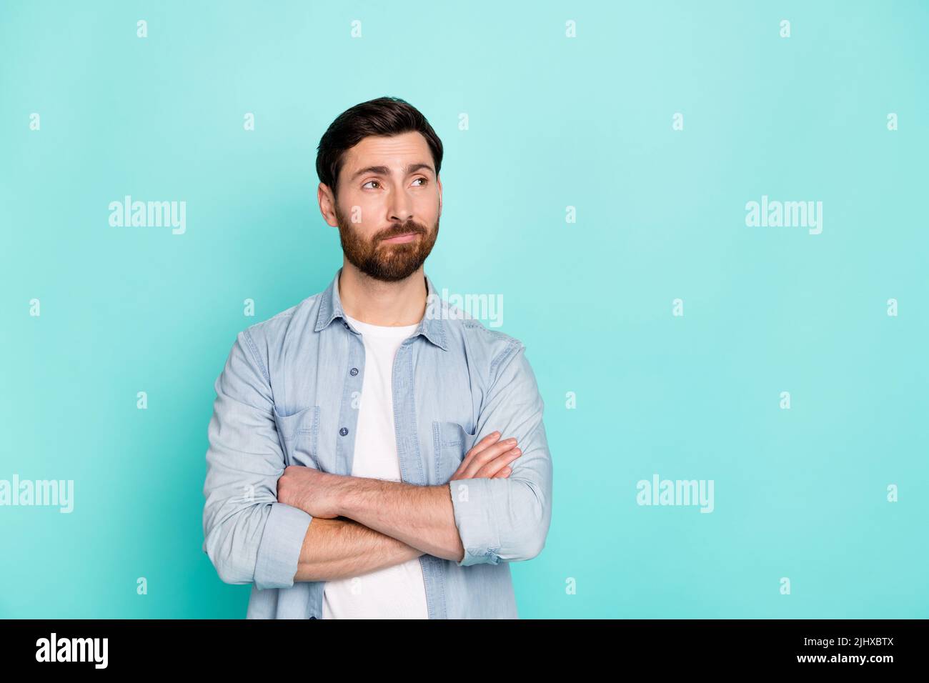 Portrait of minded smart person folded arms look empty space wonder ...