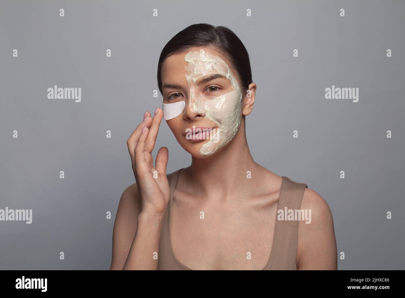Smiling beautiful lady applying skincare mask on her face. Skincare ...