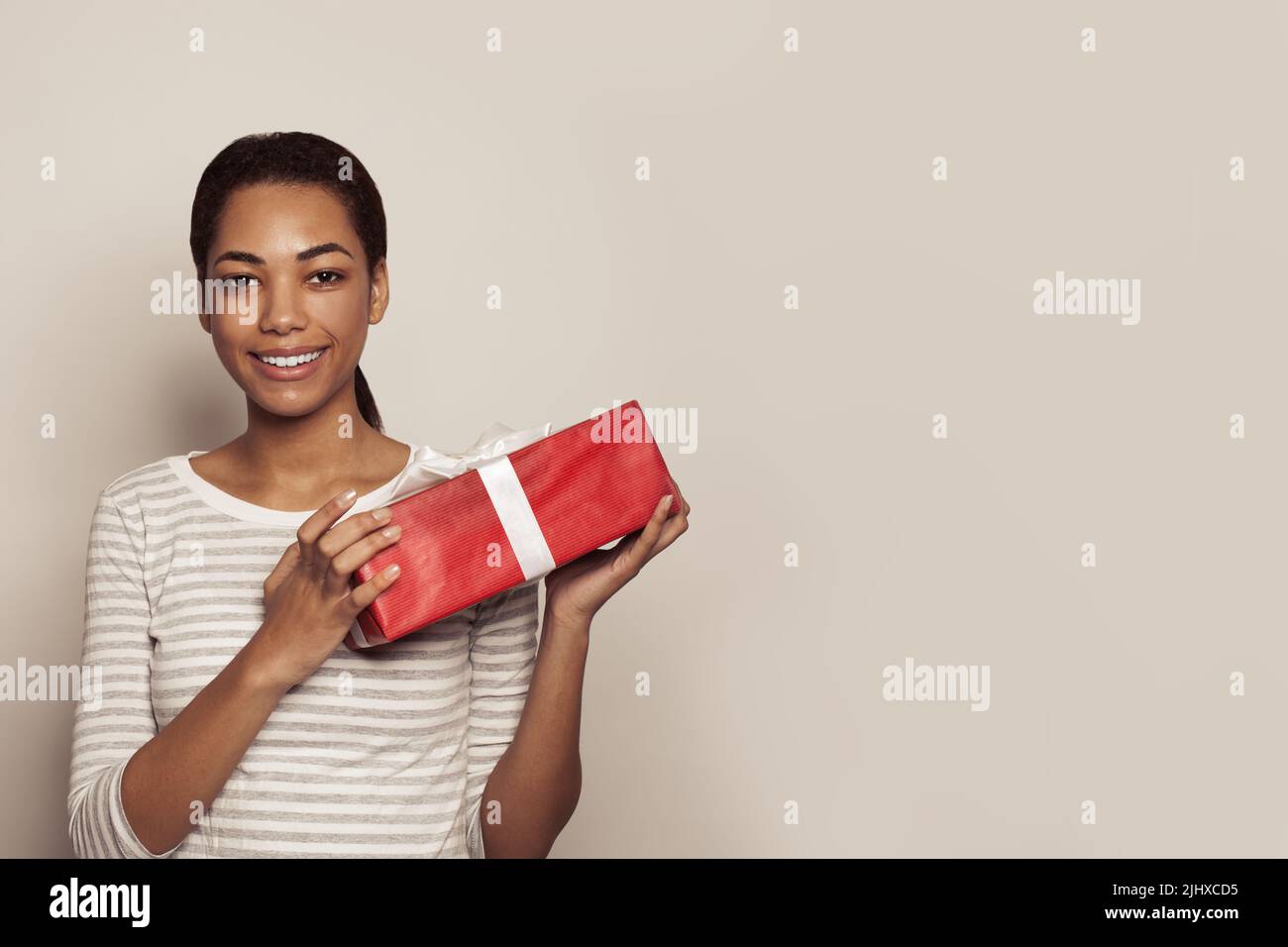 Attractive young black woman holding red gift present box with white ...