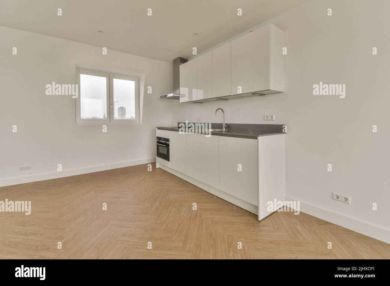 Interior of empty white kitchen with windows and wooden parquet floor ...