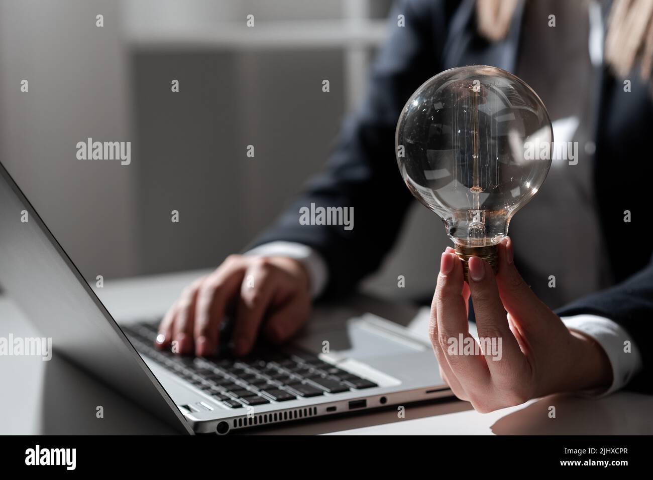 Businesswoman Typing Recent Updates On Lap Top On Desk Holding ...
