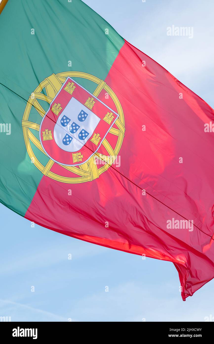 A vertical shot of Portugal flag waving during wind in background of ...